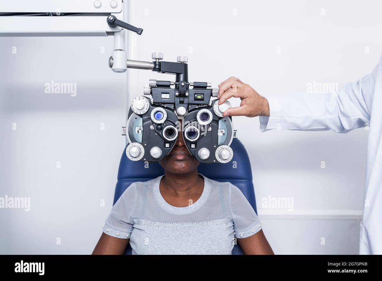 Optometrist adjusting the optometry equipment during study of the ...