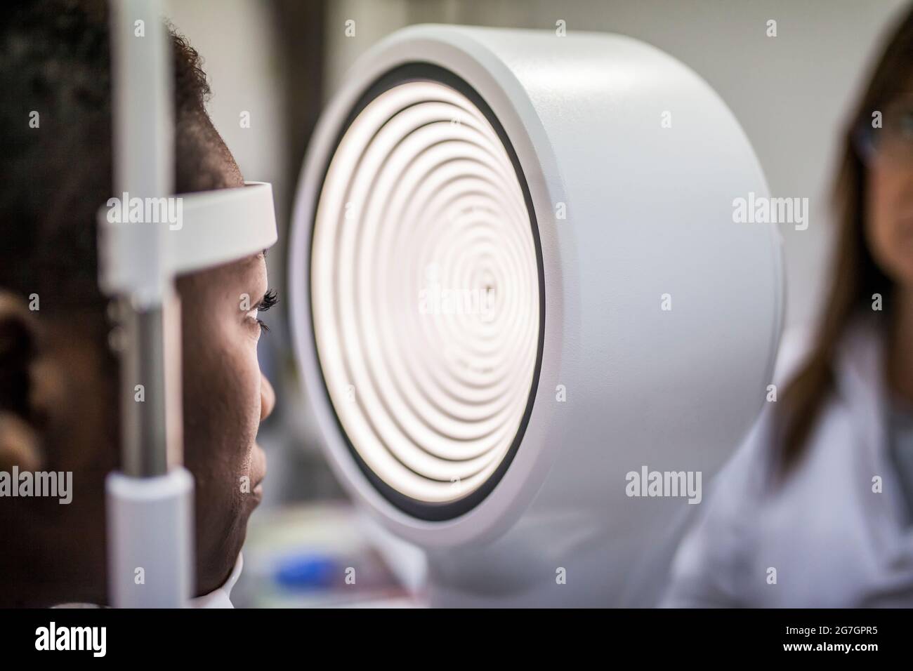 Black Woman in optometry cabinet during study of the eyesight using a ...