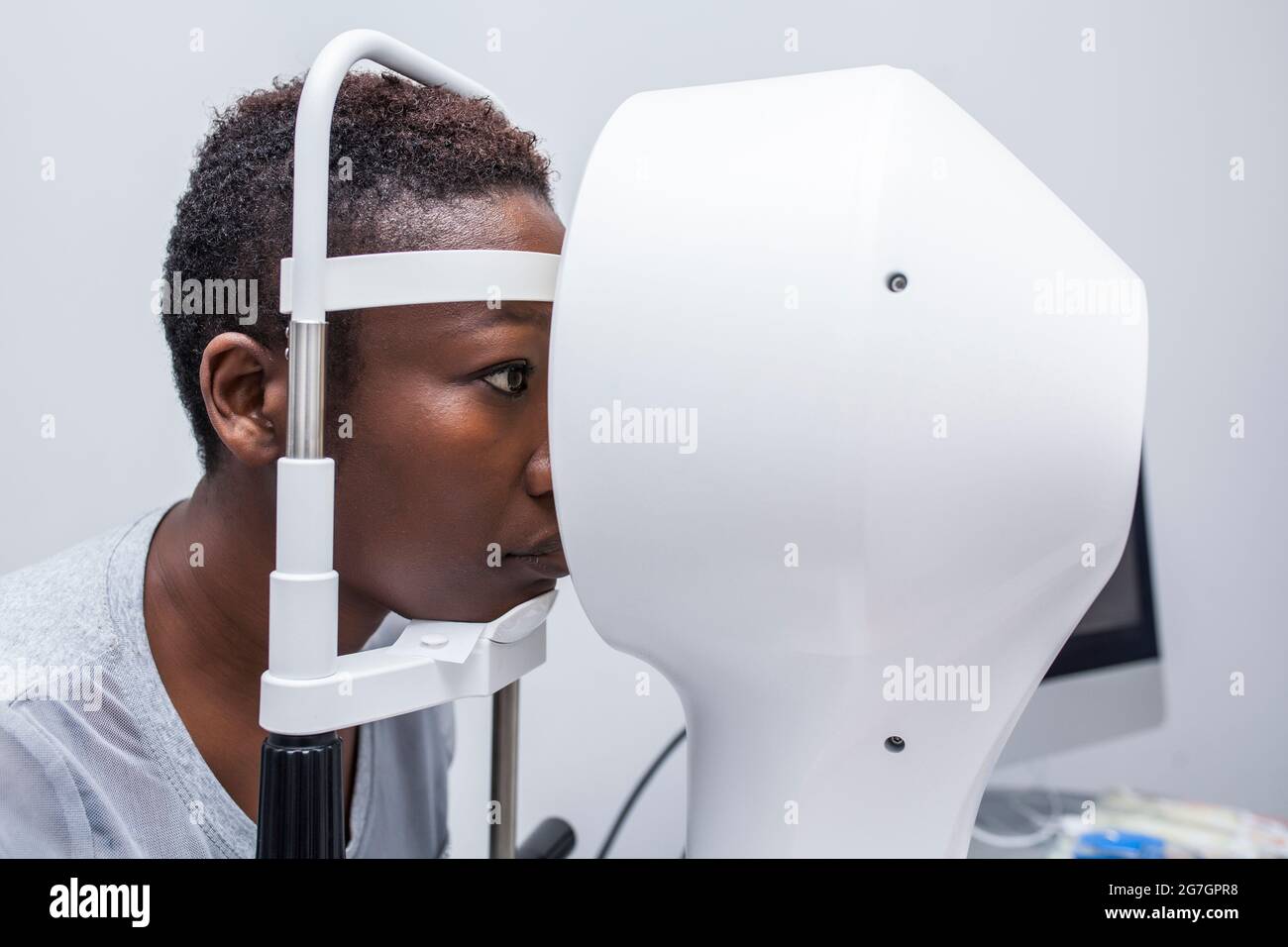 Black Woman in optometry cabinet during study of the eyesight using a ...