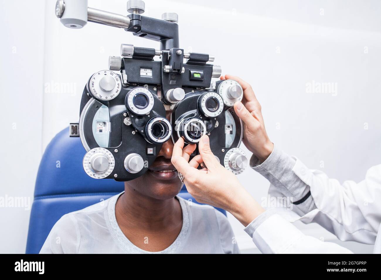 Optometrist adjusting the optometry equipment during study of the ...
