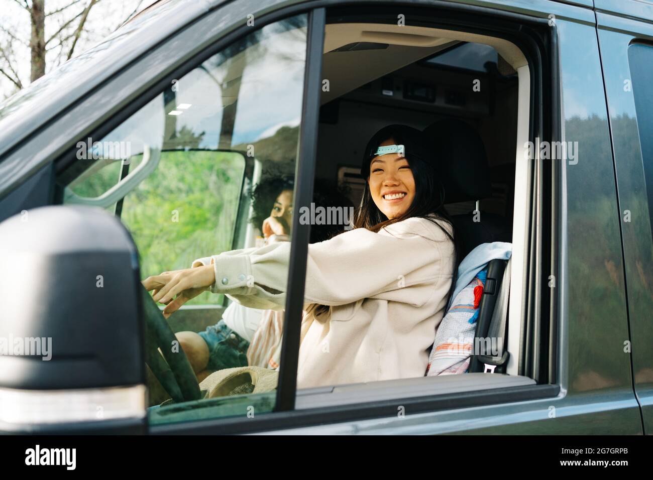 Through window side view of cheerful young Asian Woman sitting on ...