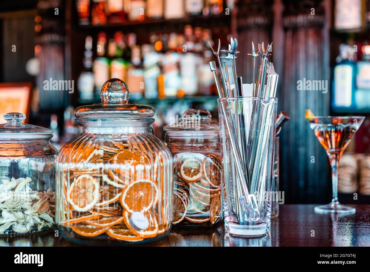 Bartender metal tools in glass and assorted decorations in jars placed ...
