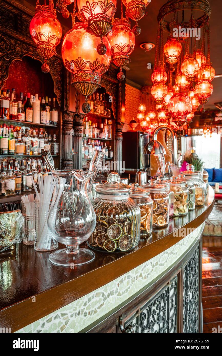 Interior of cozy pub with illuminated lamps and wooden counter with ...