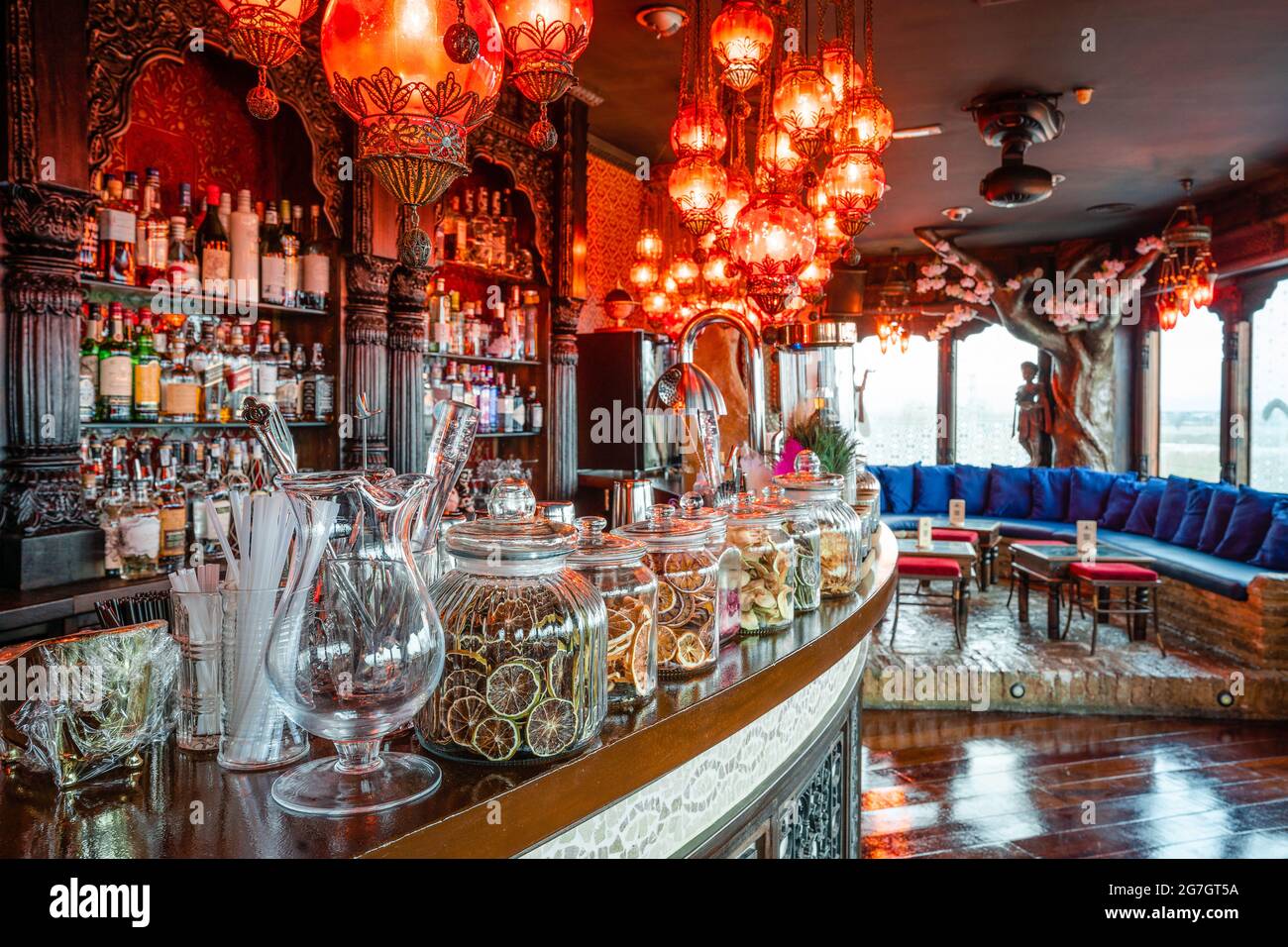 Interior of cozy pub with illuminated lamps and wooden counter with ...