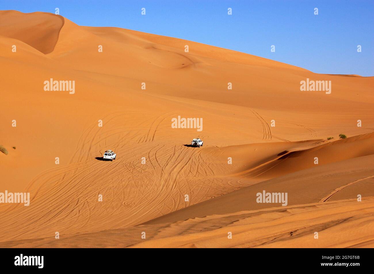 Two four wheel drive vehicles travelling across the treacherous Ubari ...
