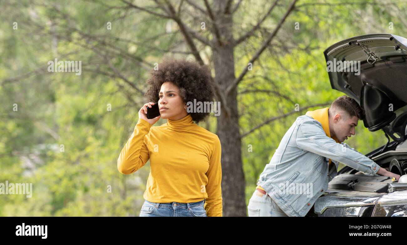 Shocked black Woman making call to emergency service while young man ...