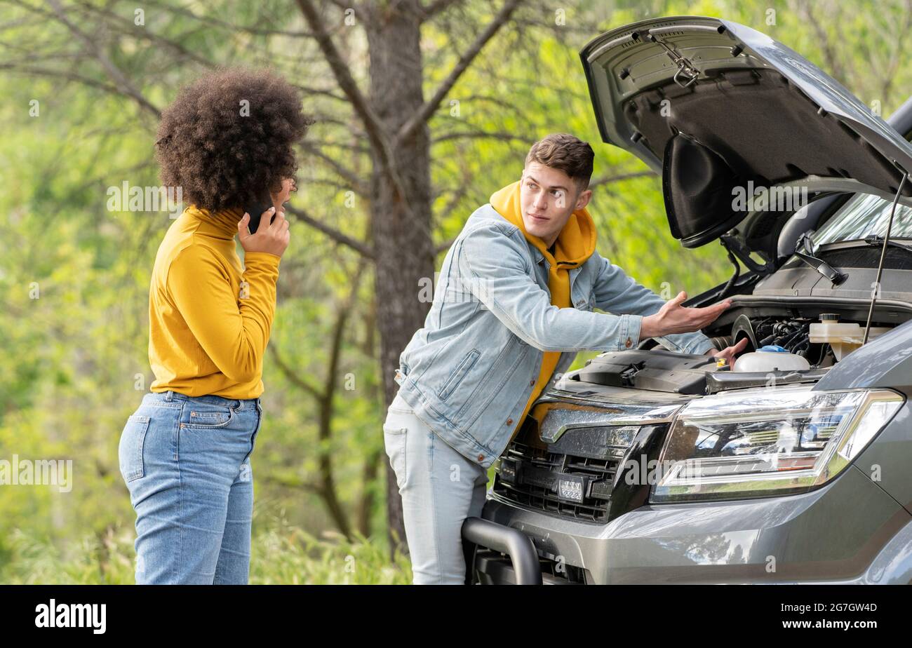 Shocked black Woman making call to emergency service while young man ...