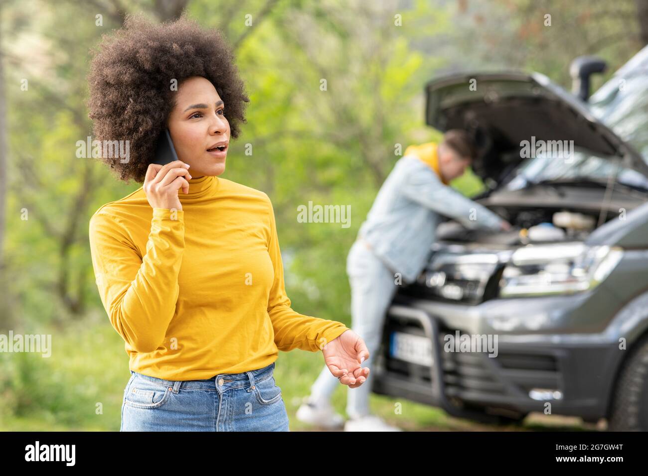 Shocked black Woman making call to emergency service while young man ...