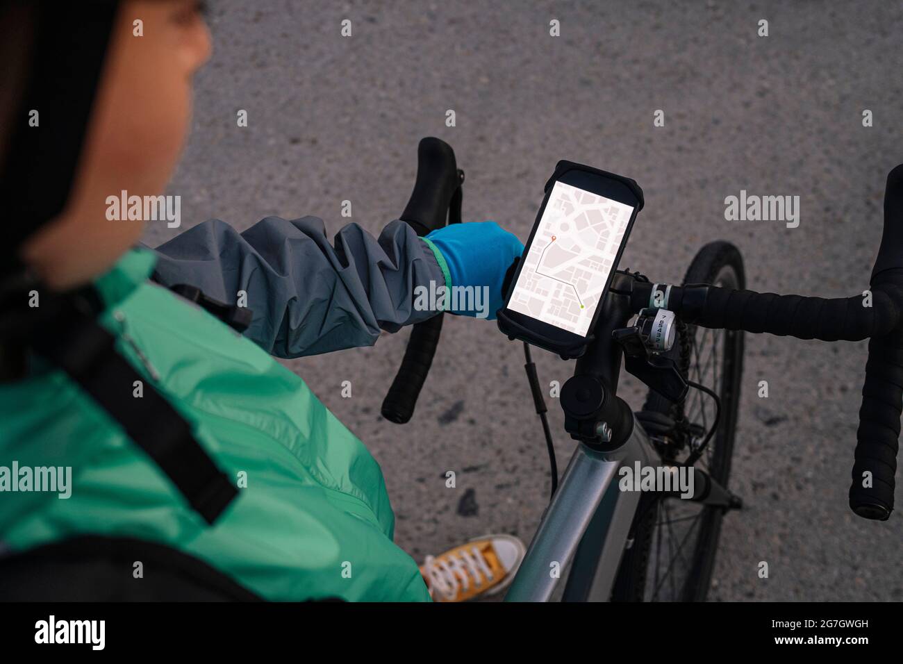 From above anonymous courier examining route on GPS map before riding ...