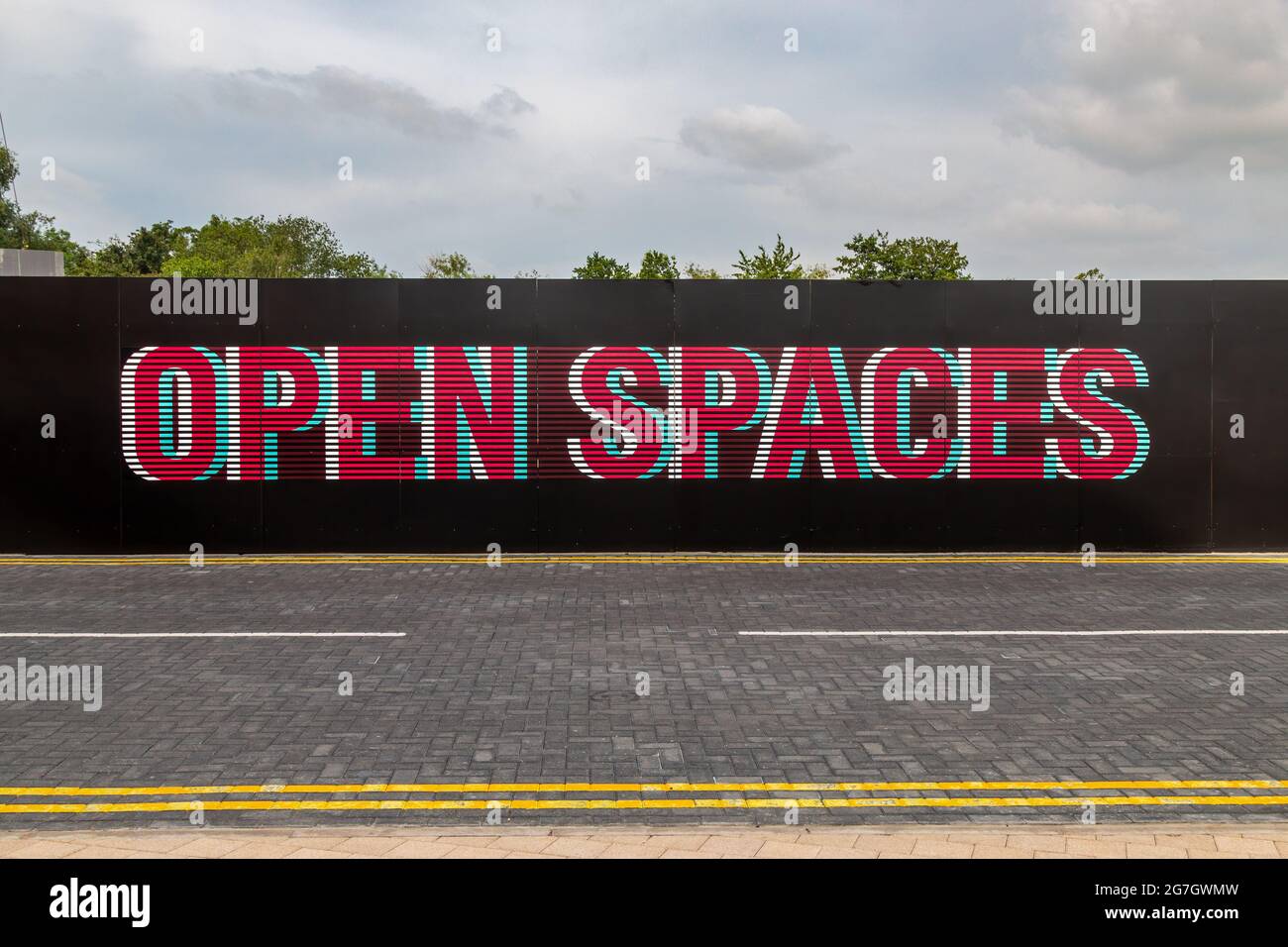 Tall, solid, black fence with Open Spaces painted on it. Cambridge, UK ...