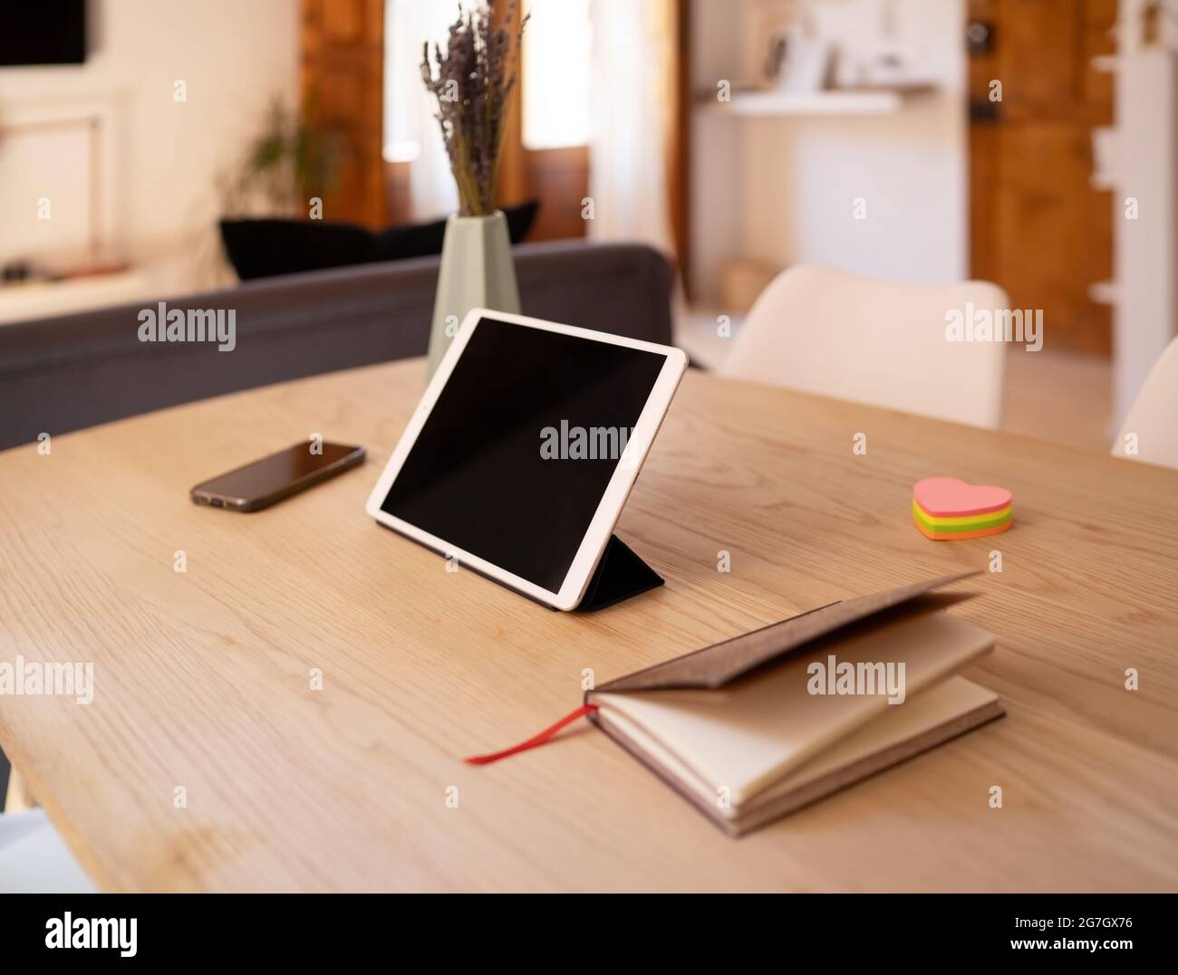 Modern tablet with black screen placed on table with smartphone and ...
