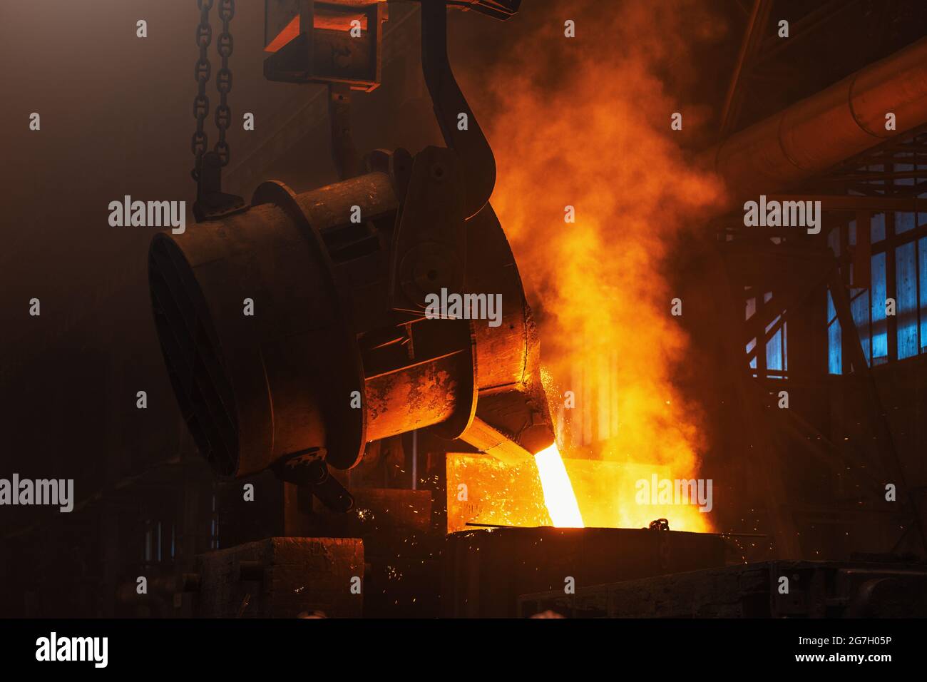 Molten metal casting. Pouring iron with smoke and sparks. Metallurgical ...