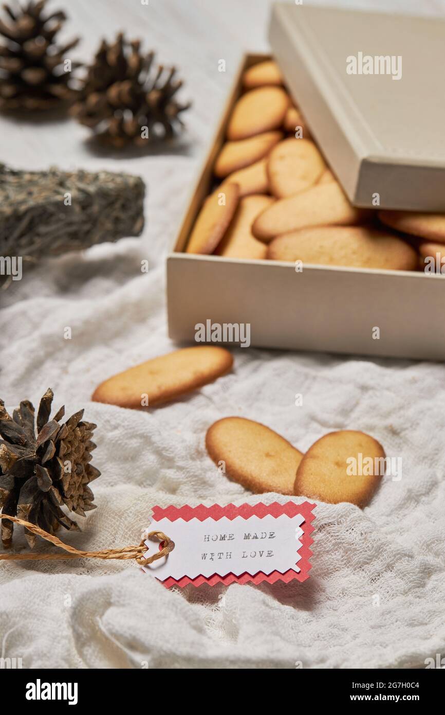 High angle of gift tag and cones placed on table with box full of ...