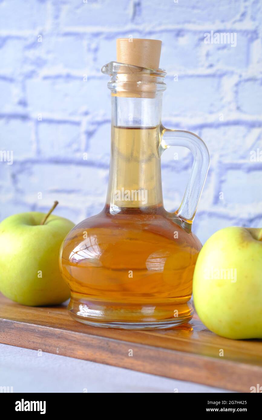 apple vinegar in glass bottle with fresh green apple on table Stock ...