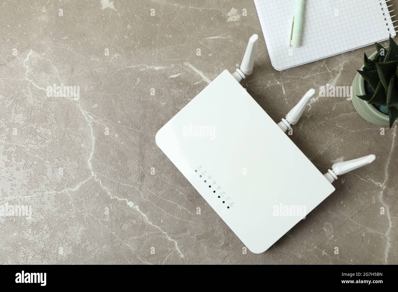 Workplace with Wi - fi router on gray textured table Stock Photo - Alamy