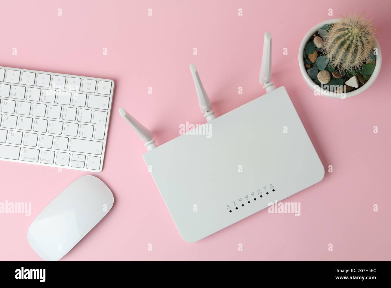 Workplace with Wi - fi router on pink background Stock Photo - Alamy