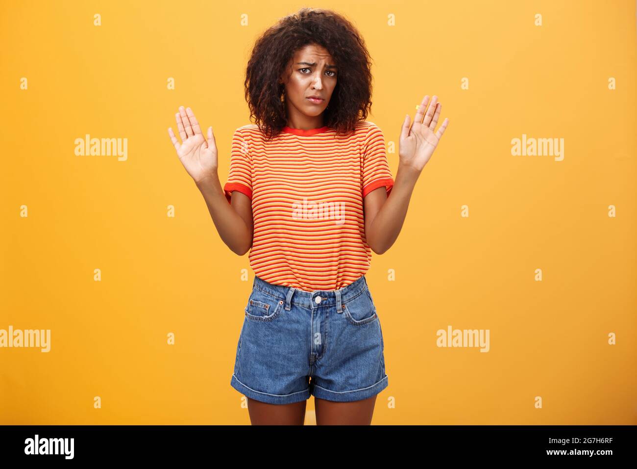 Silly insecure and sad dark-skinned female model in trendy striped t ...