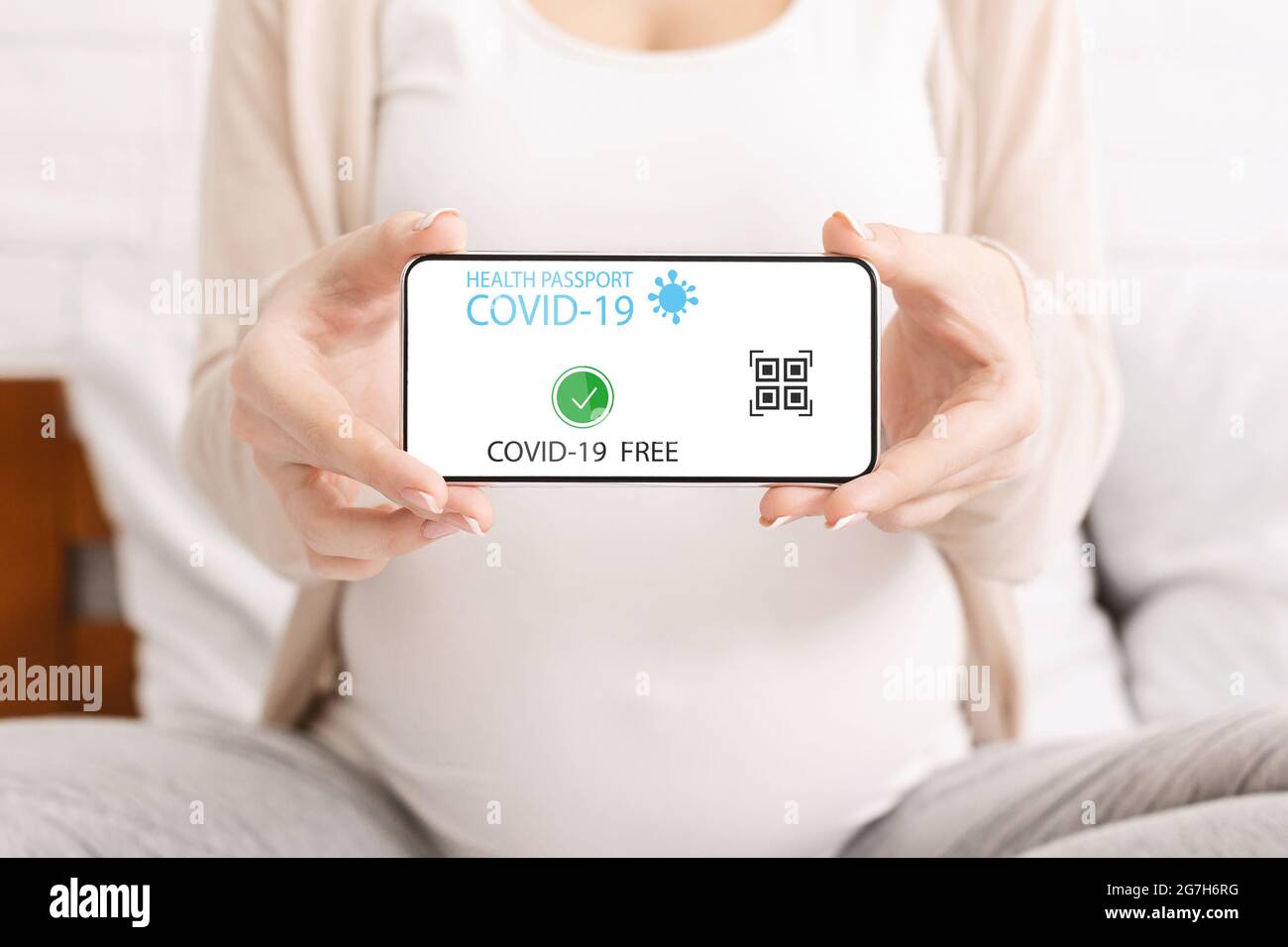 Closeup of pregnant woman holding and showing mobile phone with ...