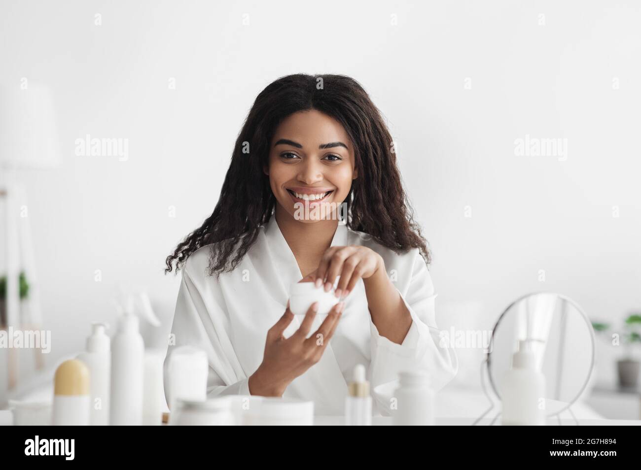 Morning routine. Beautiful african american woman in bathrobe after ...