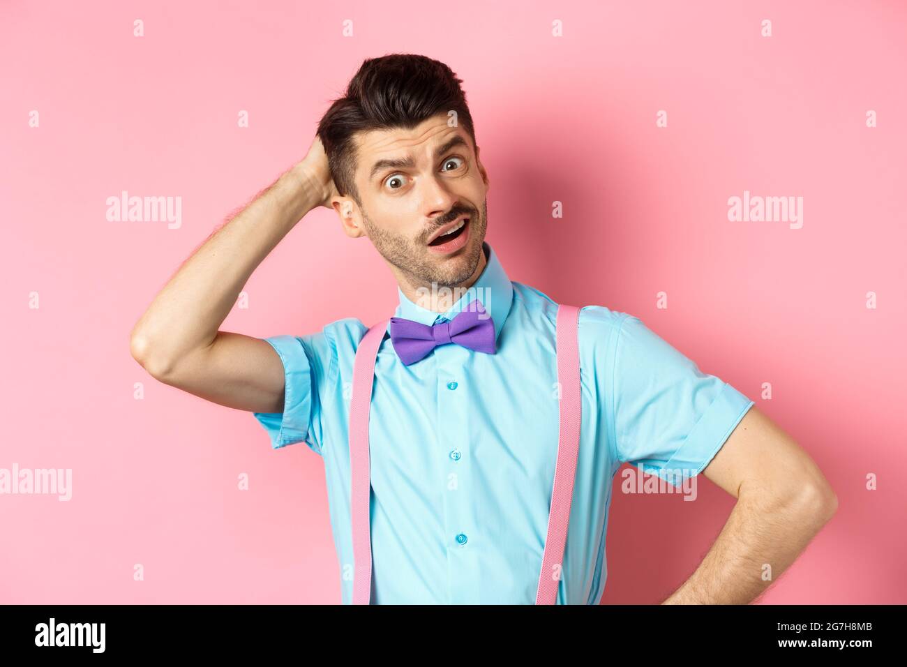Confused funny man scratching head, staring puzzled at camera, know ...