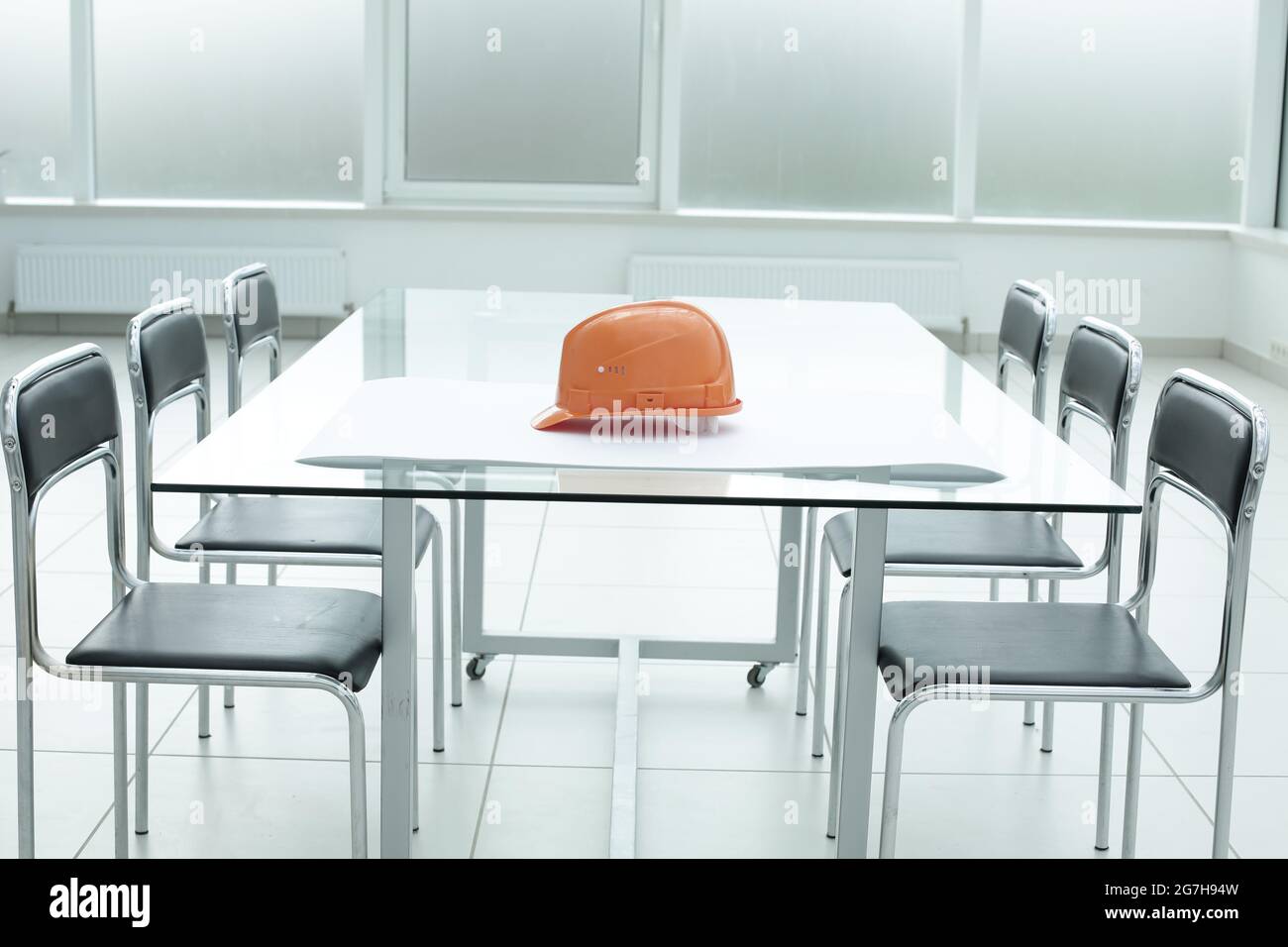Construction hard hat blueprints on glass table in office space Stock ...