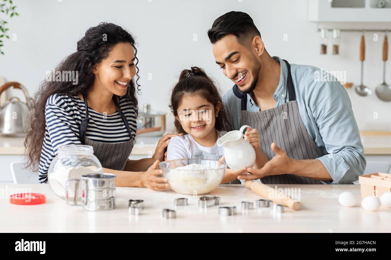 Happy middle-eastern family making homemade cookies together at kitchen ...