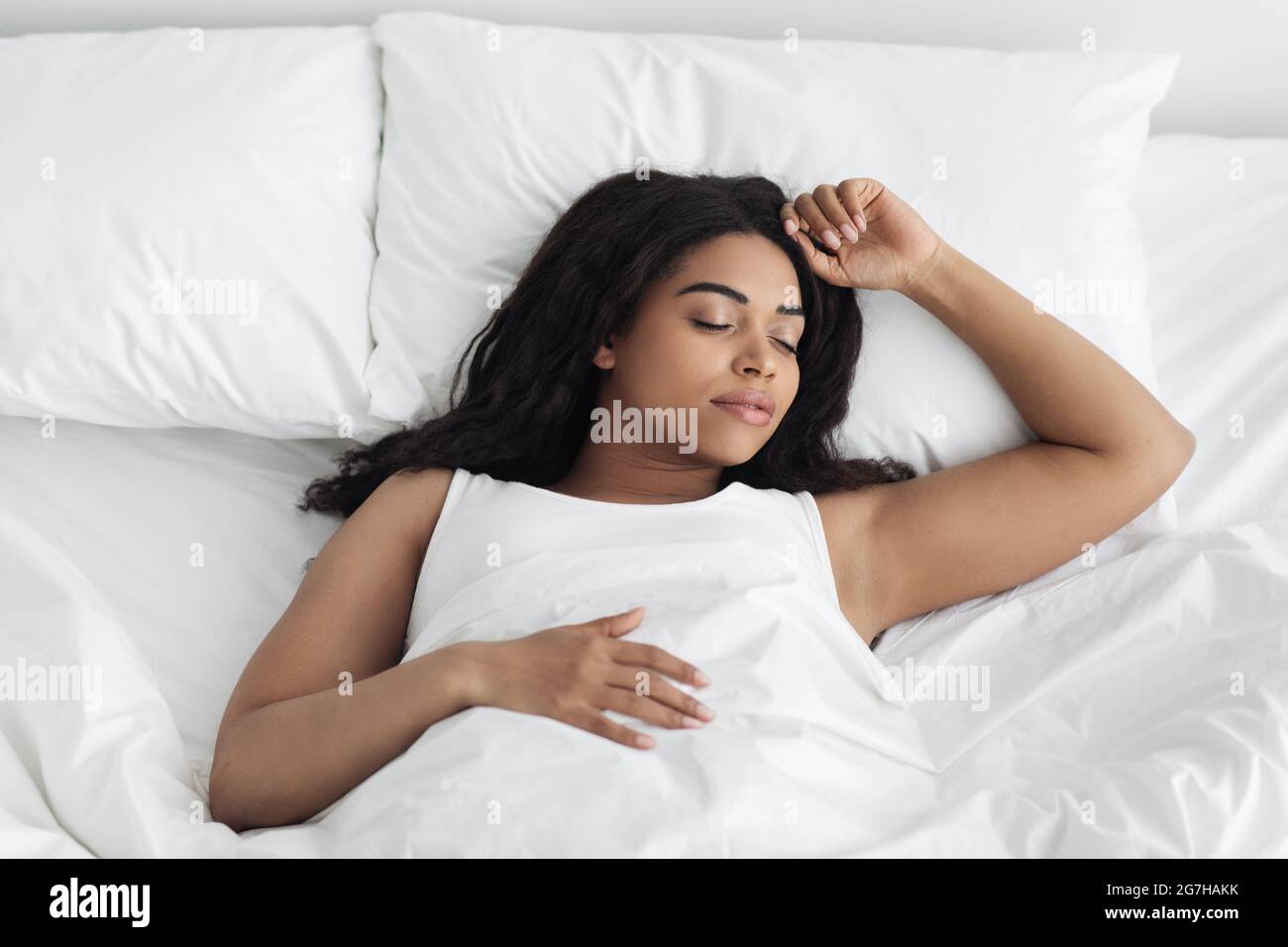Cozy bedtime. Young african american woman sleeping in white bed at ...