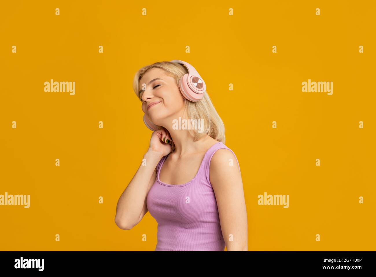 Carefree mood. Happy lady enjoying music in wireless headphones ...