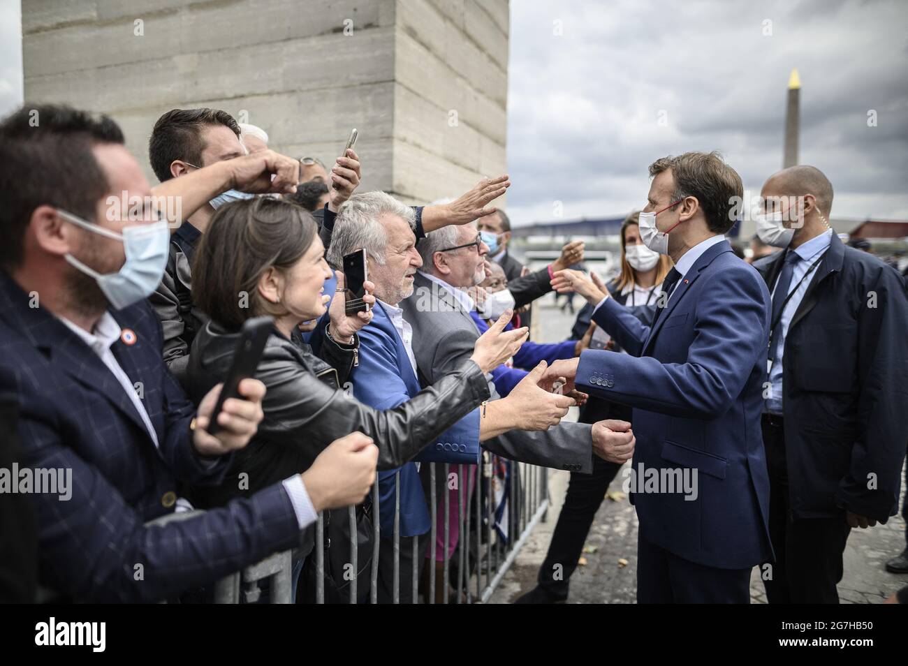 French President Emmanuel Macron (C) meets spectators at the end of the ...