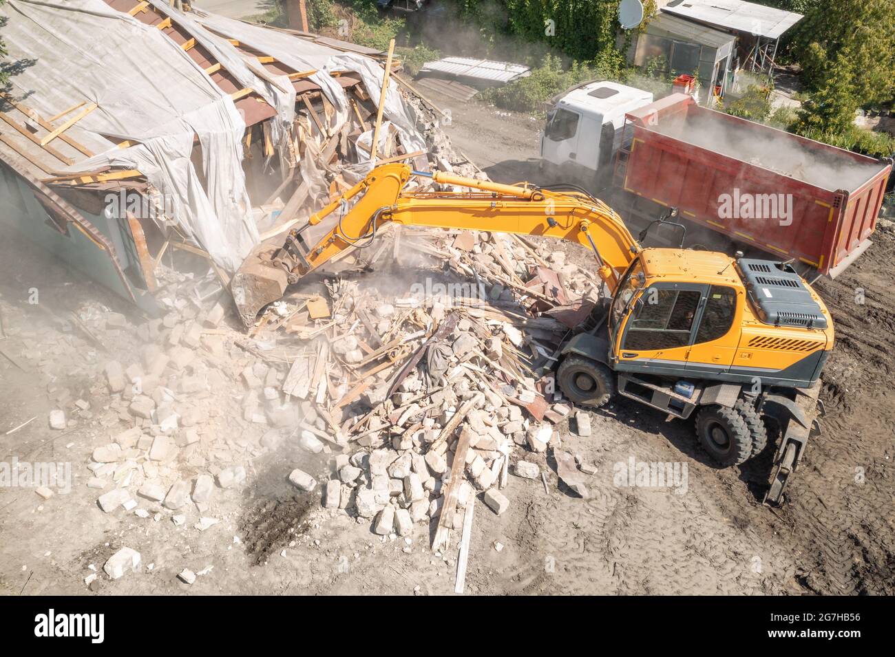 Demolition of old house building for new construction by excavator ...