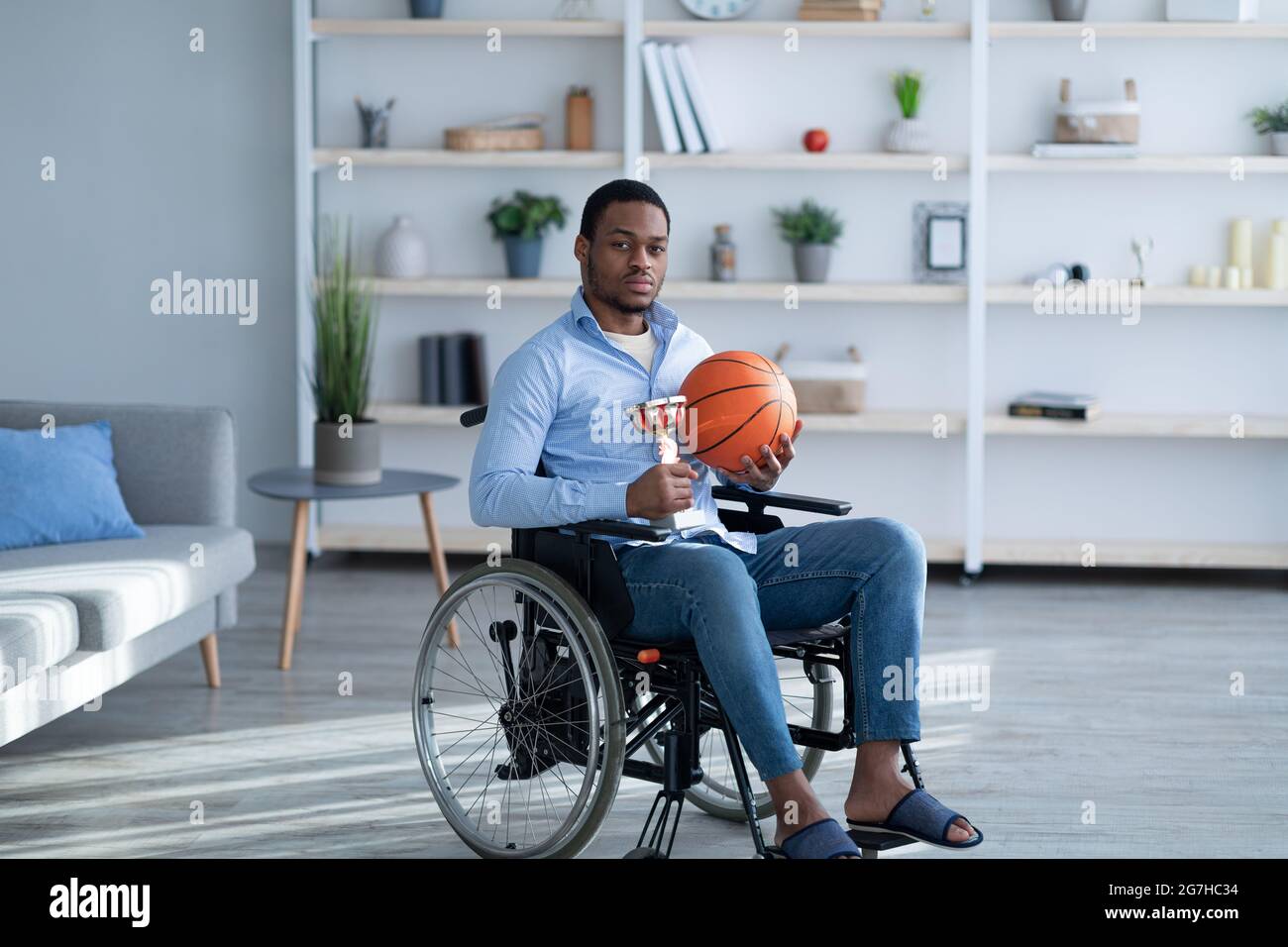 Full length of paraplegic basketball player in wheelchair holding ...