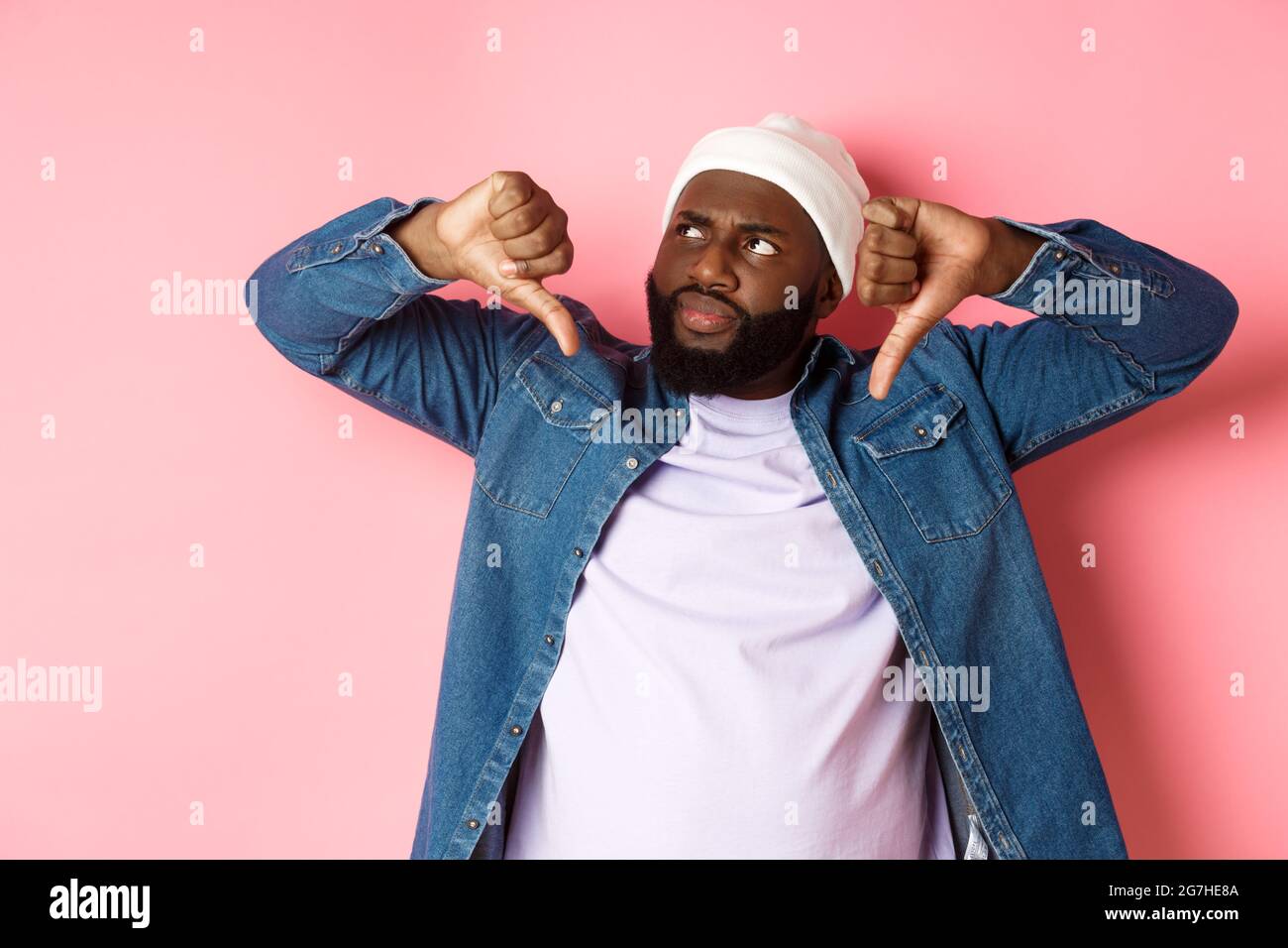 Disappointed Black man staring at upper left corner annoyed, showing ...