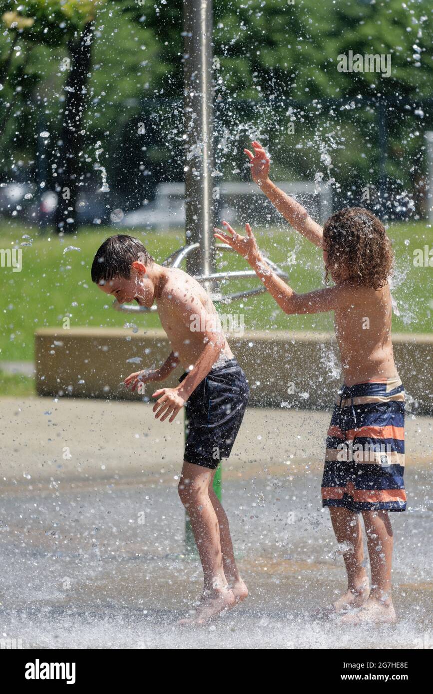 Two boys (9yr olds) playing in water games and fountains in Quebec City ...