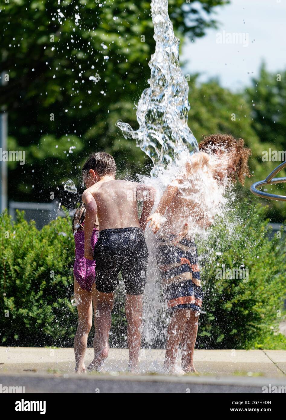 Three children playing in water games and fountains in Quebec City ...