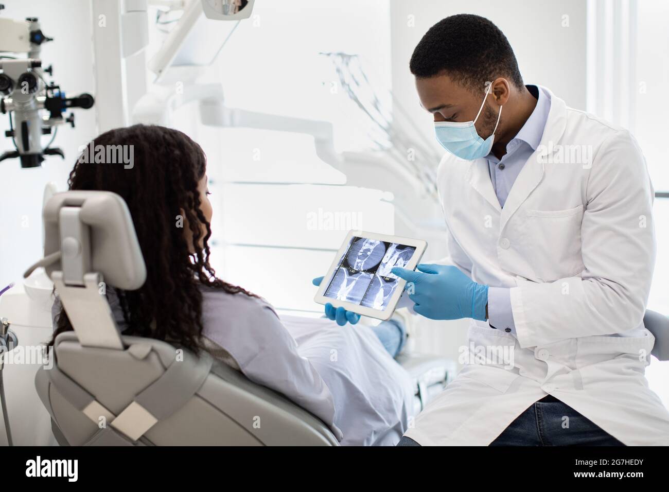 Black Stomatologist Doctor Showing Teeth Xray Picture On Digital Tablet ...