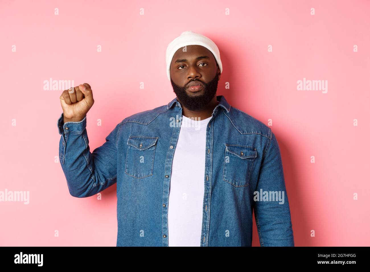 Serious and confident african-american male activist, raising fist ...