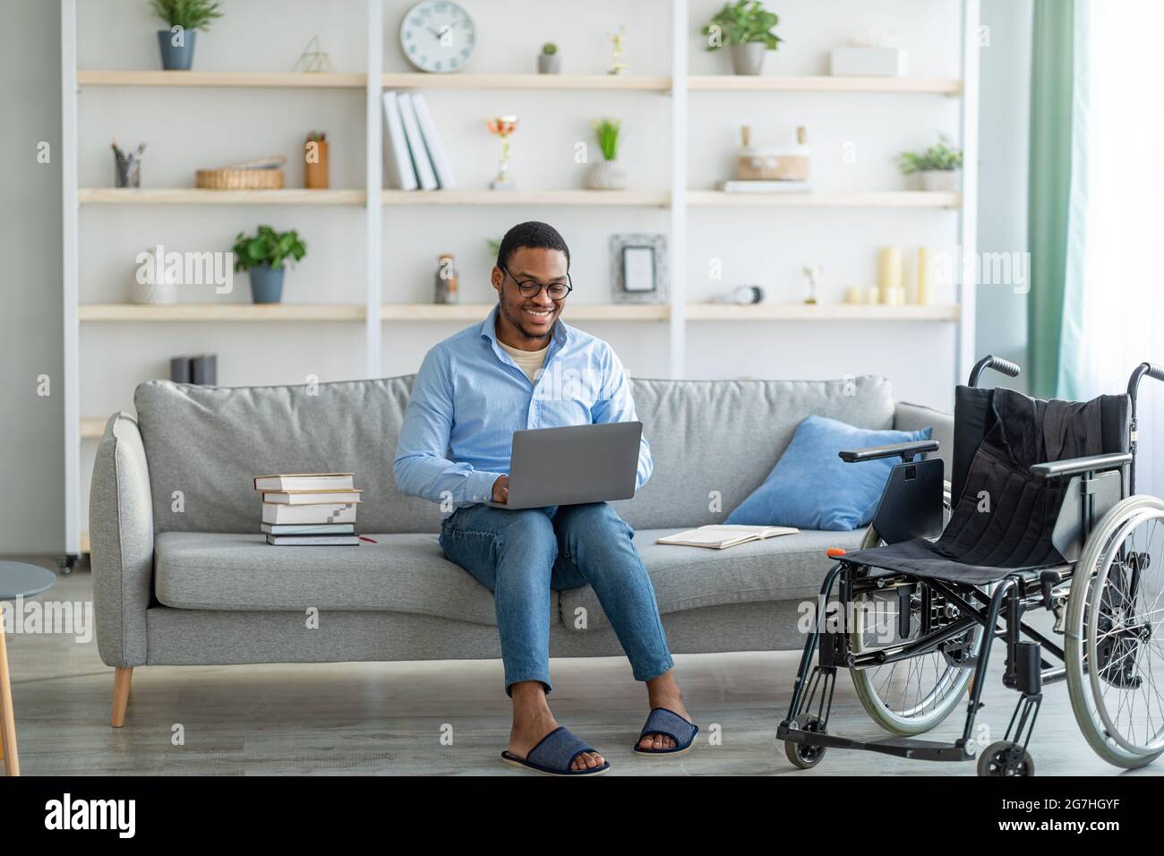 Handicapped African American freelancer in wheelchair doing work ...