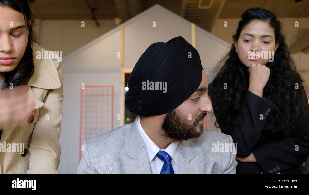Group of Indian co-workers brainstorming during a business meeting ...