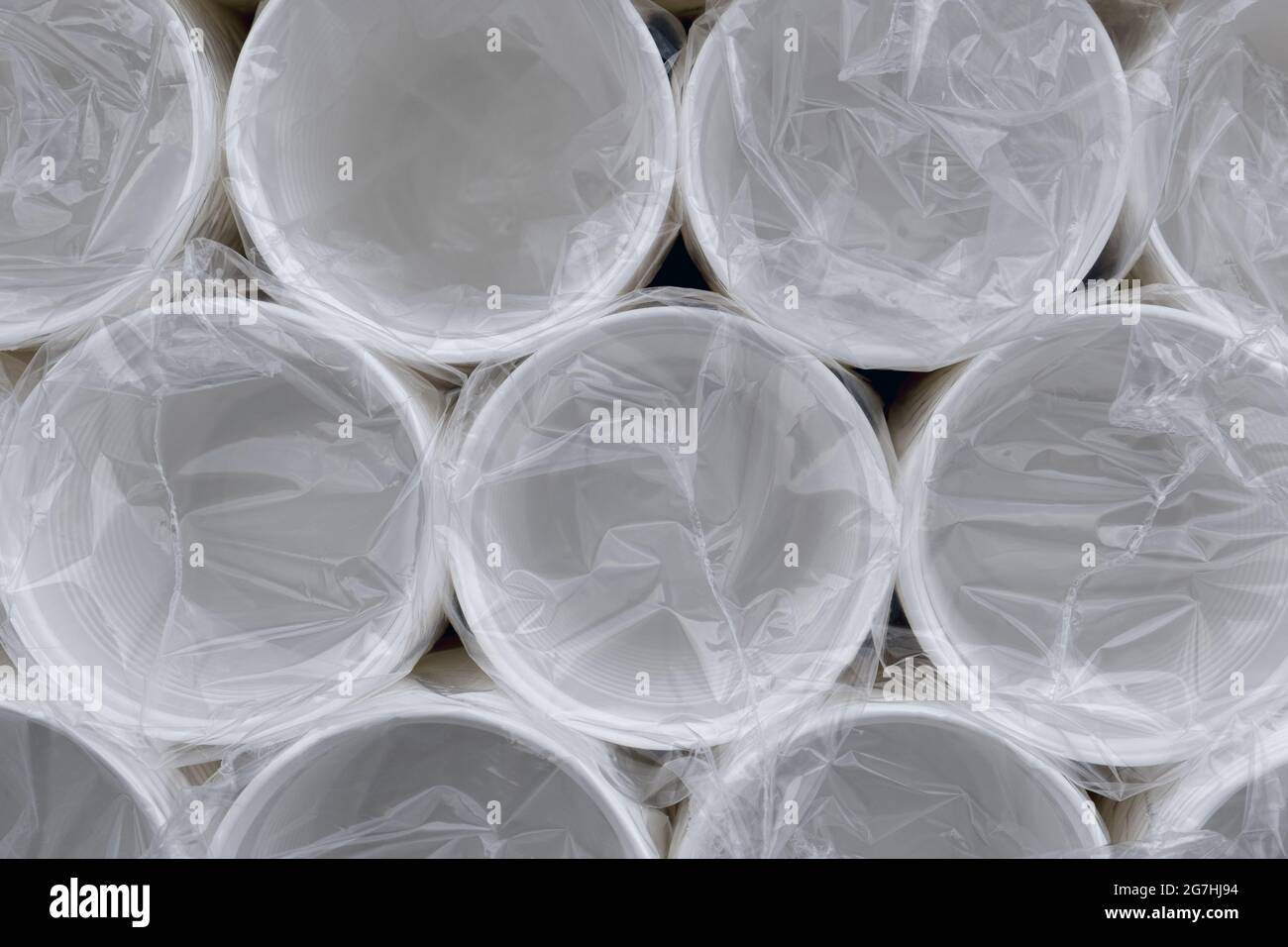 Lot of plastic cups in piles disposable drinking. Stack of white clean ...