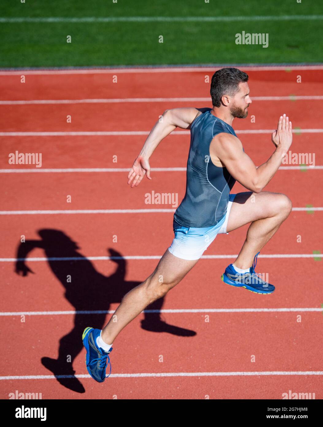 energetic athletic muscular man runner running on racetrack at outdoor ...