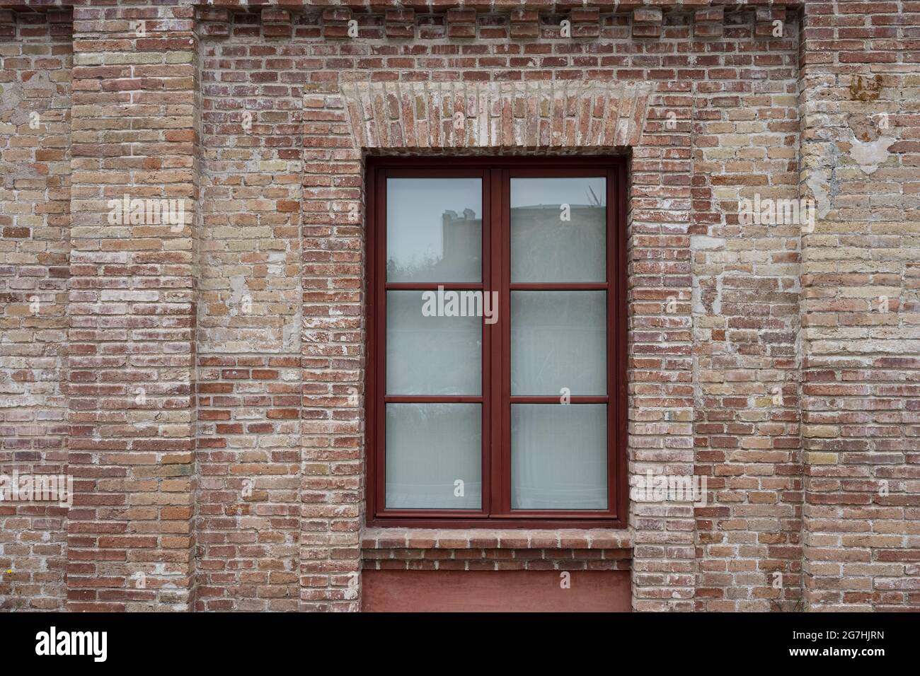 Closeup of a window with blinds of a brick building in the daylight ...