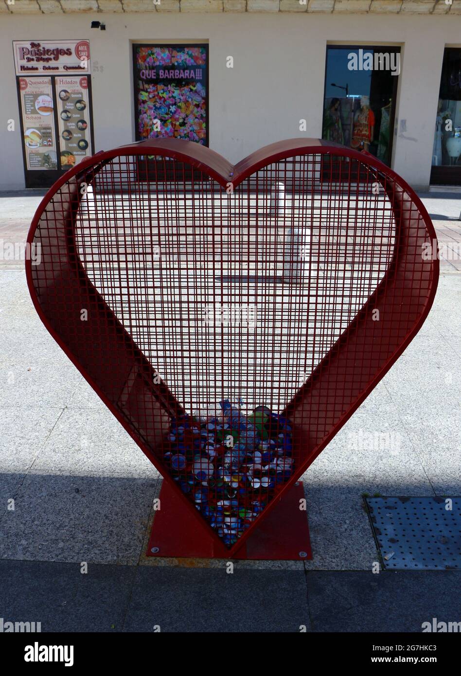 Heart shaped red recycling bin for plastic caps in a street in Santona ...