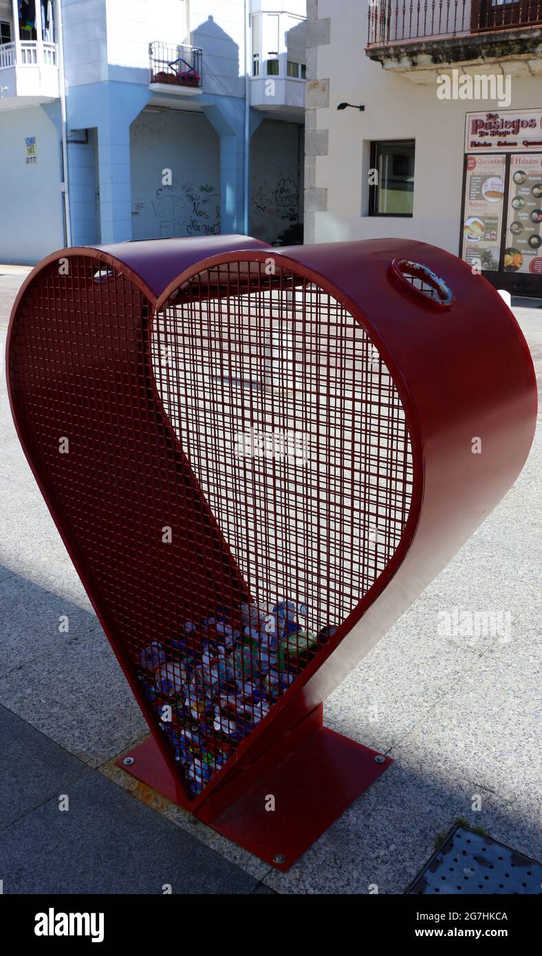 Heart shaped red recycling bin for plastic caps in a street in Santona ...