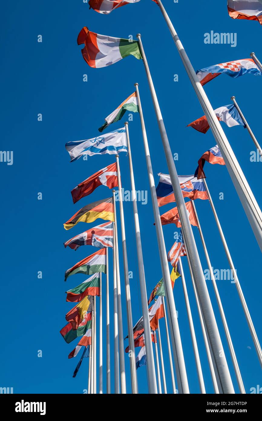Different flags fluttering on flagpoles Stock Photo - Alamy