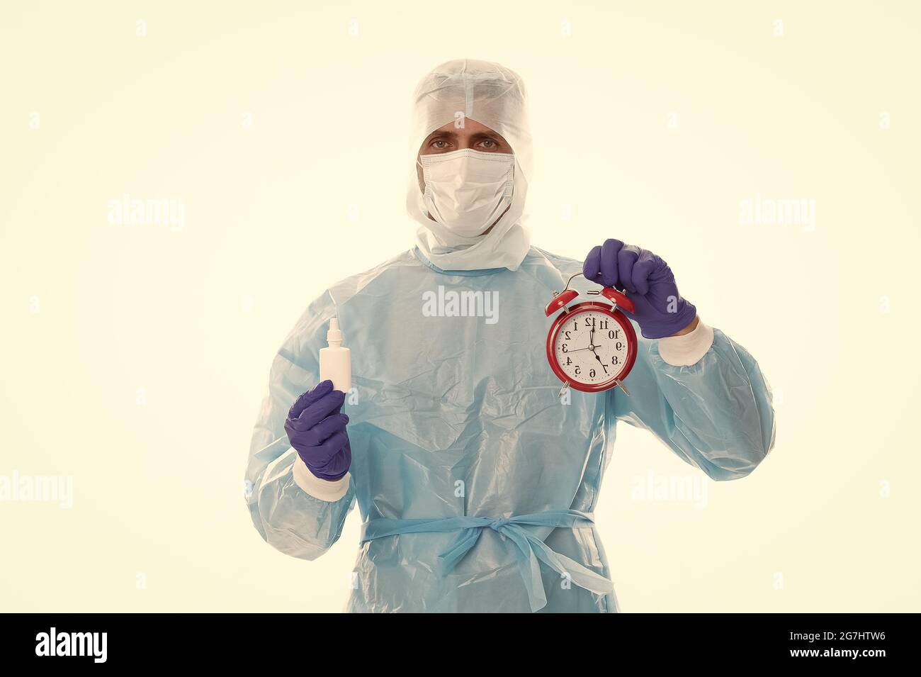 Physician in personal protective equipment hold alarm clock and ...