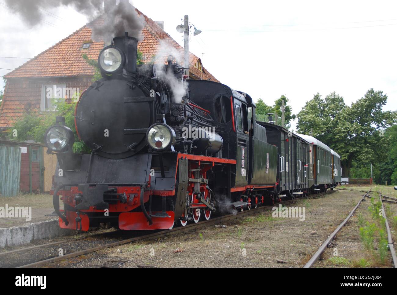 Old steam engine locomotive move on trail. Narrow-gauge railway retro ...
