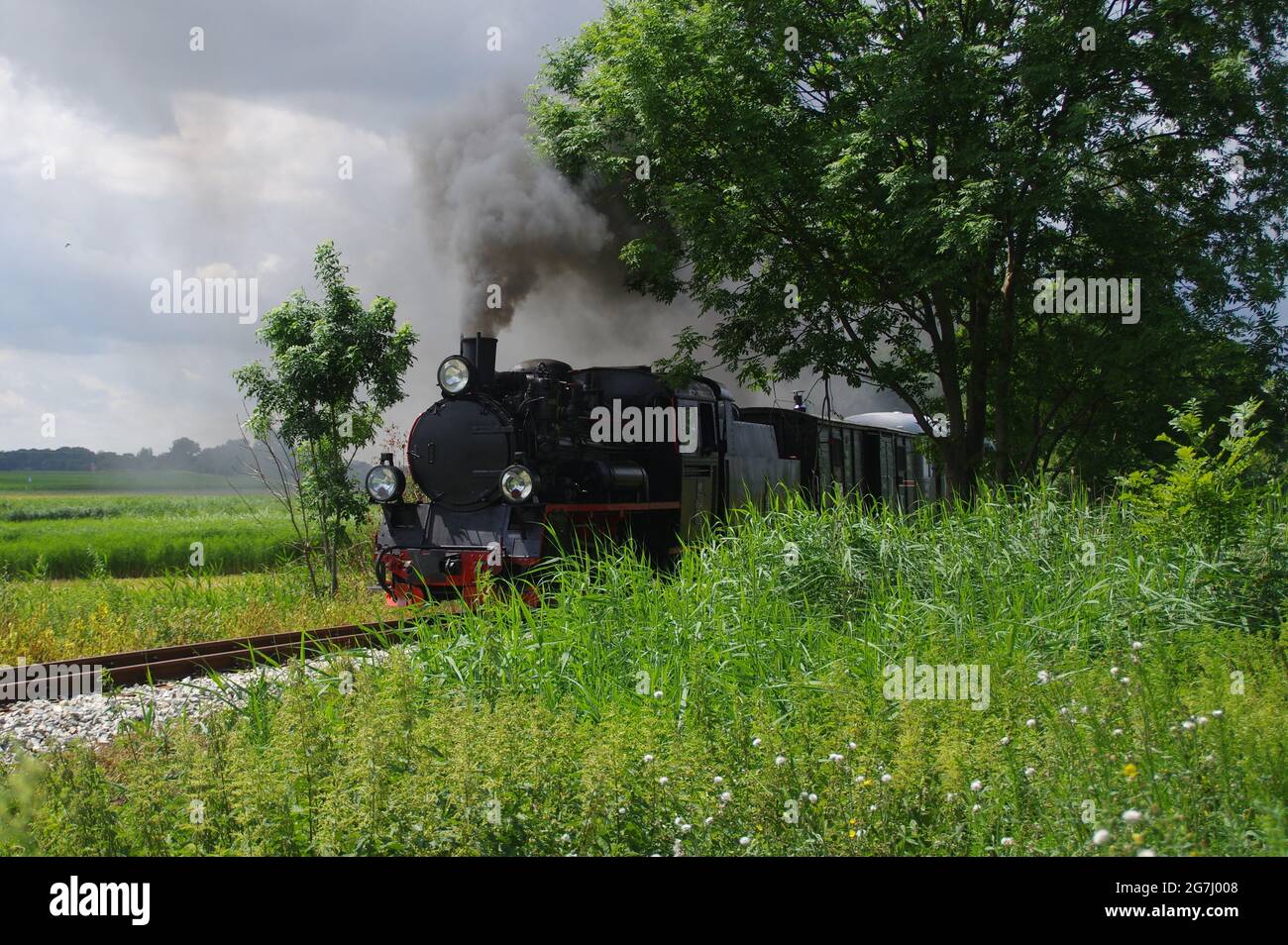 Old steam engine locomotive move on trail. Narrow-gauge railway retro ...