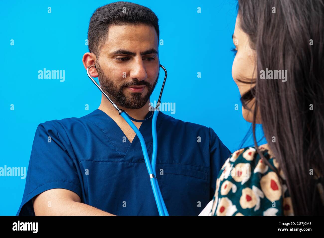 Arab doctor in a blue uniform standing with the stethoscope and ...