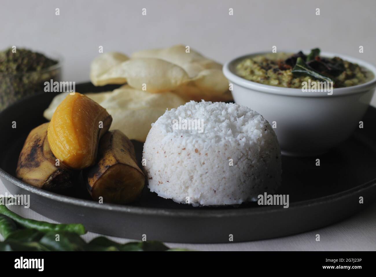 Steamed rice cake served with steamed plantain, green gram curry and ...