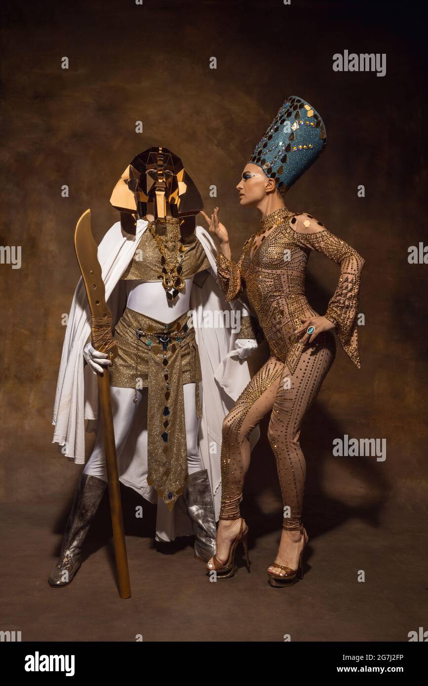 Young woman in image of Nefertiti in art performance isolated on brown ...